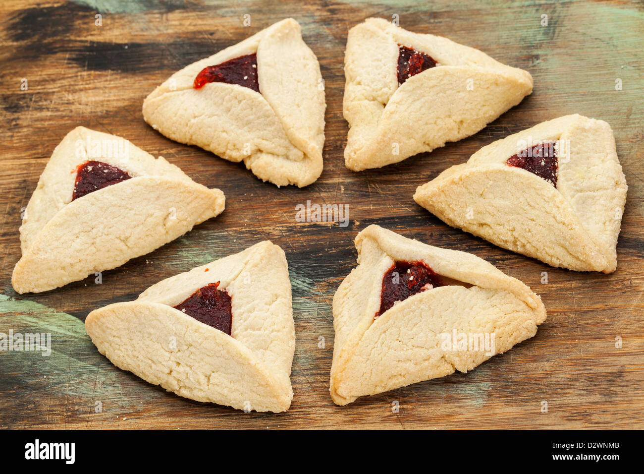 raspberry hamantaschen cookies on a wooden cutting board - a ...