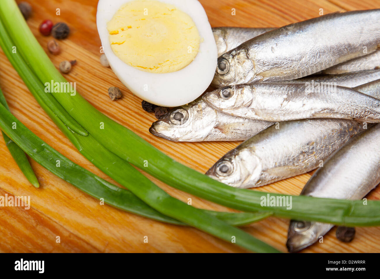 salted anchovies, egg, and spring onion on wooden background Stock ...