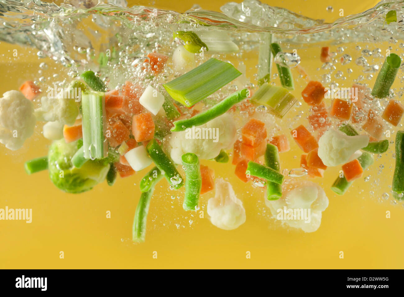 Vegetables splash in water soup cooking unique concept Stock Photo - Alamy