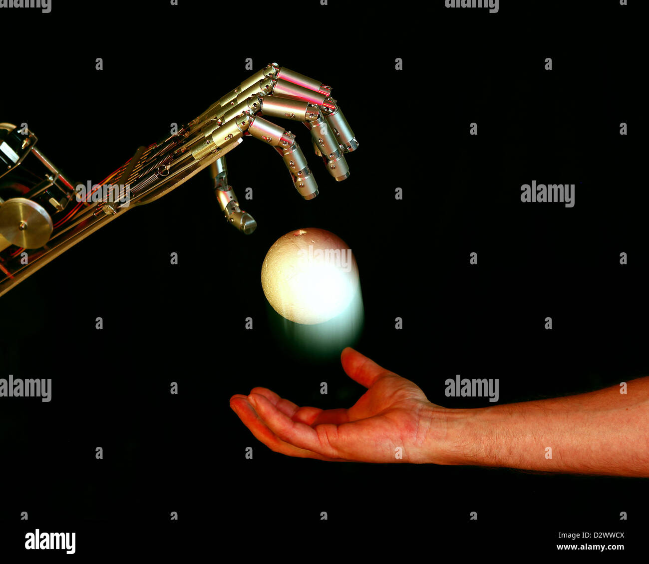 Berlin, Germany, Bionic hand and human hand with a ball Stock Photo - Alamy