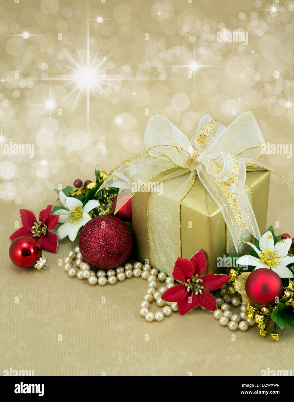 Gold wrapped present with burning candle and festive decorations Stock ...