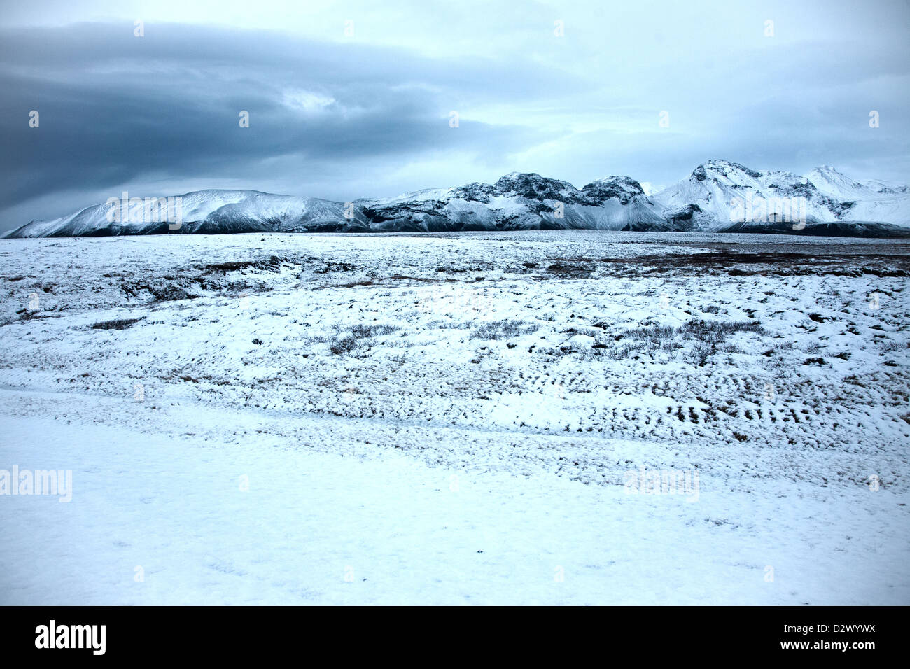Landscape of blue tinged snow-capped mountains at twilight on a return ...
