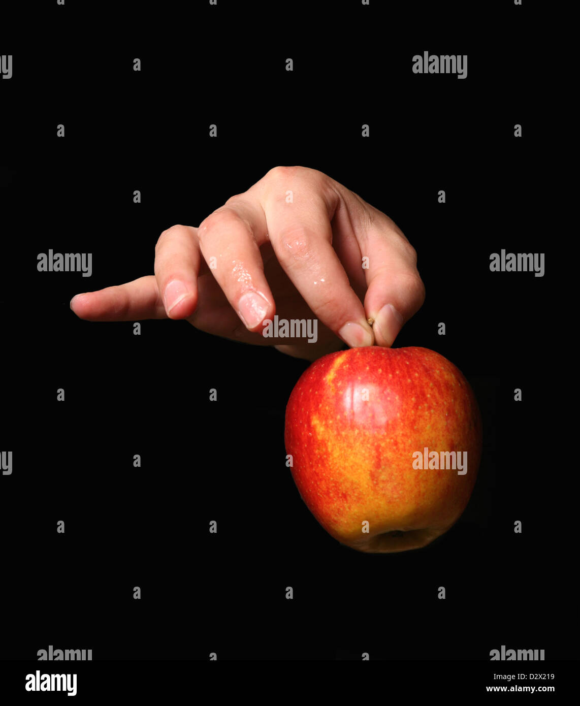 Man's hand with a red apple on a black background Stock Photo - Alamy