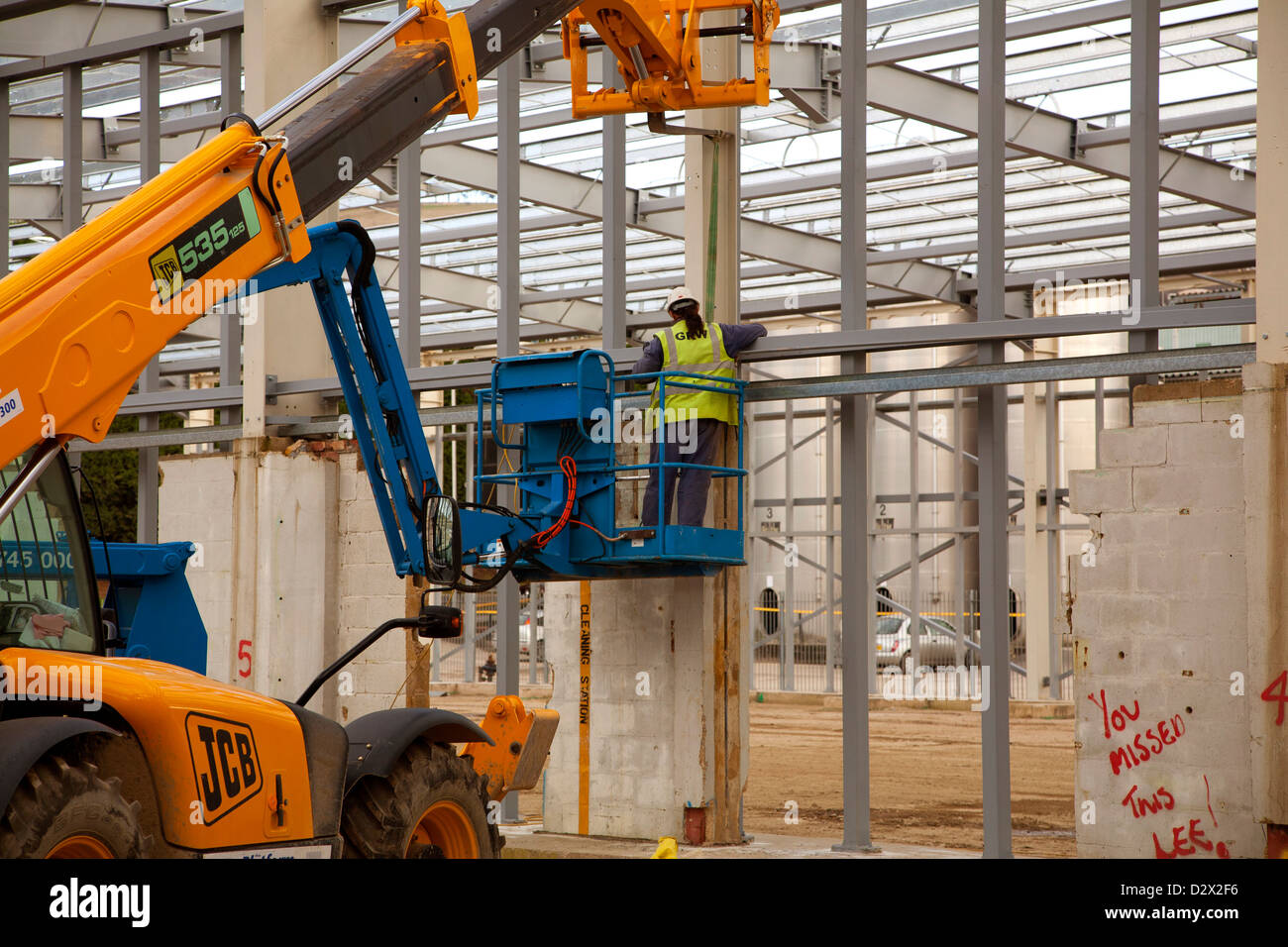 Construction working in a cage at heights on a building site Stock ...