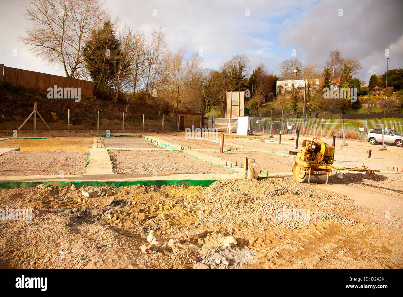 Construction ground works and a roller, with concrete strip footings ...
