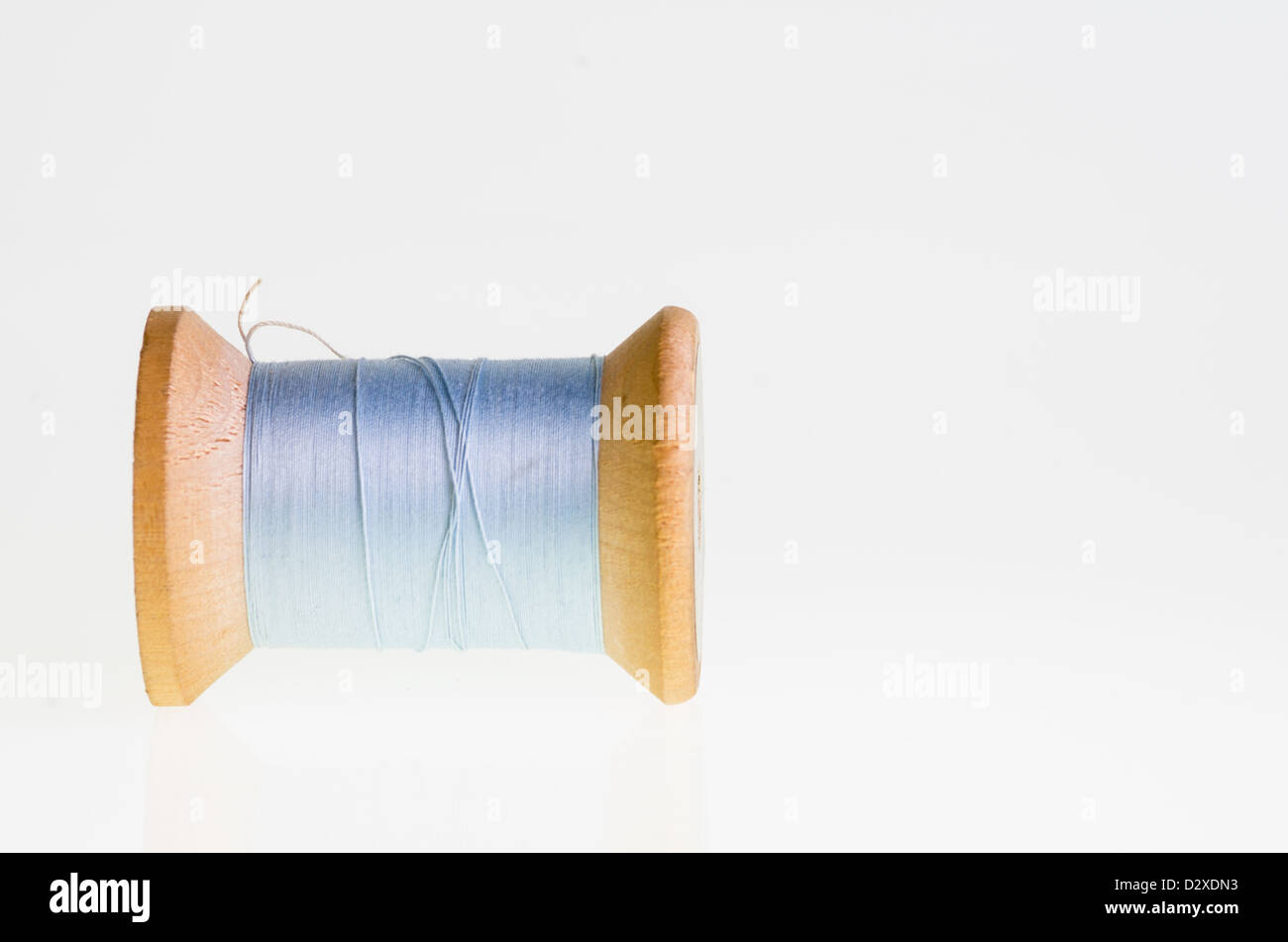 A spool of blue sewing thread isolated on white Stock Photo - Alamy