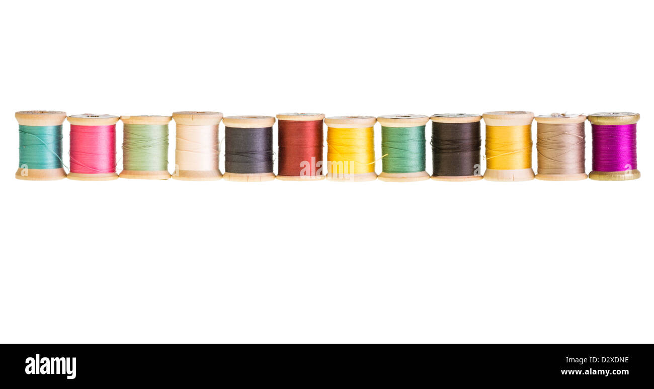 A row of sewing thread spools isolated on white Stock Photo - Alamy