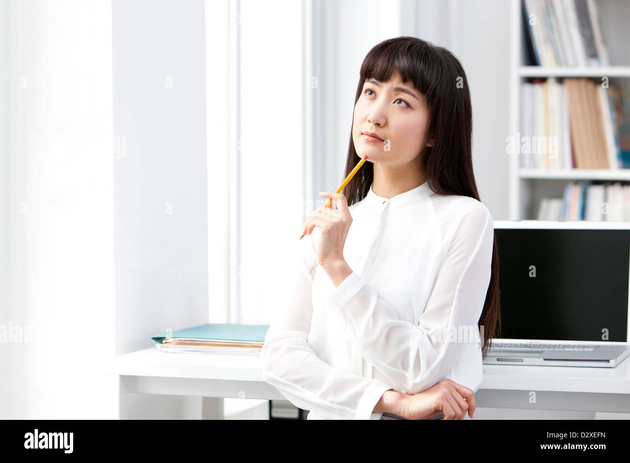 Young businesswoman thinking in the office Stock Photo - Alamy