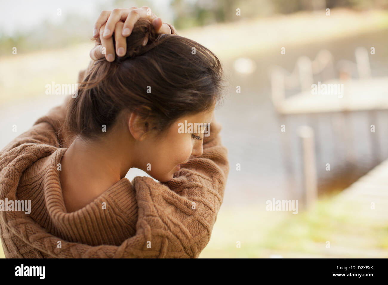 Woman with hands in hair at lakeside Stock Photo - Alamy
