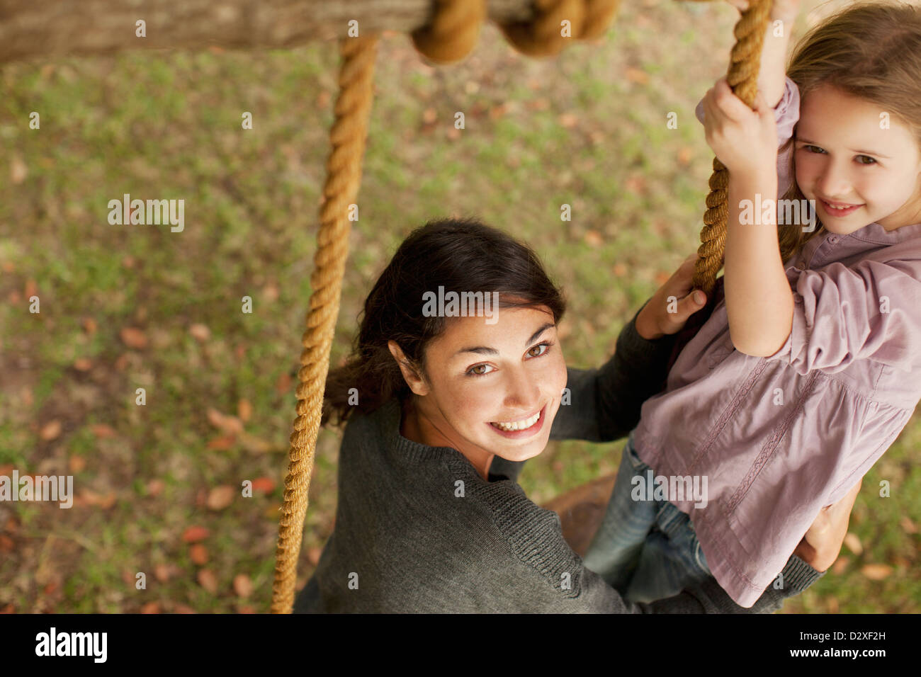 Portrait of smiling mother and daughter on swing Stock Photo - Alamy