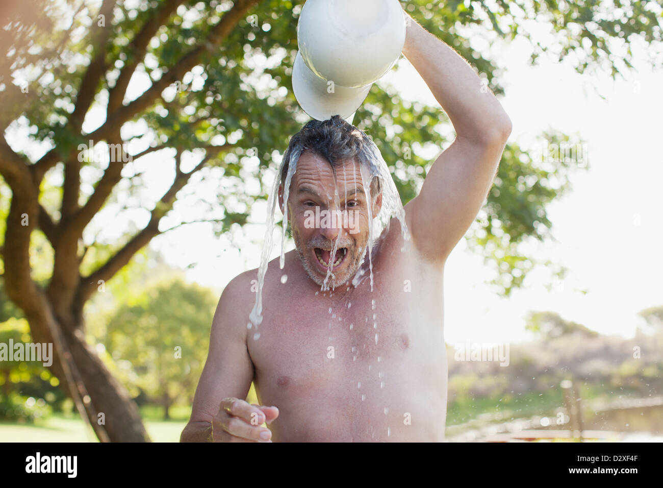 Portrait of enthusiastic man pouring water overhead Stock Photo - Alamy