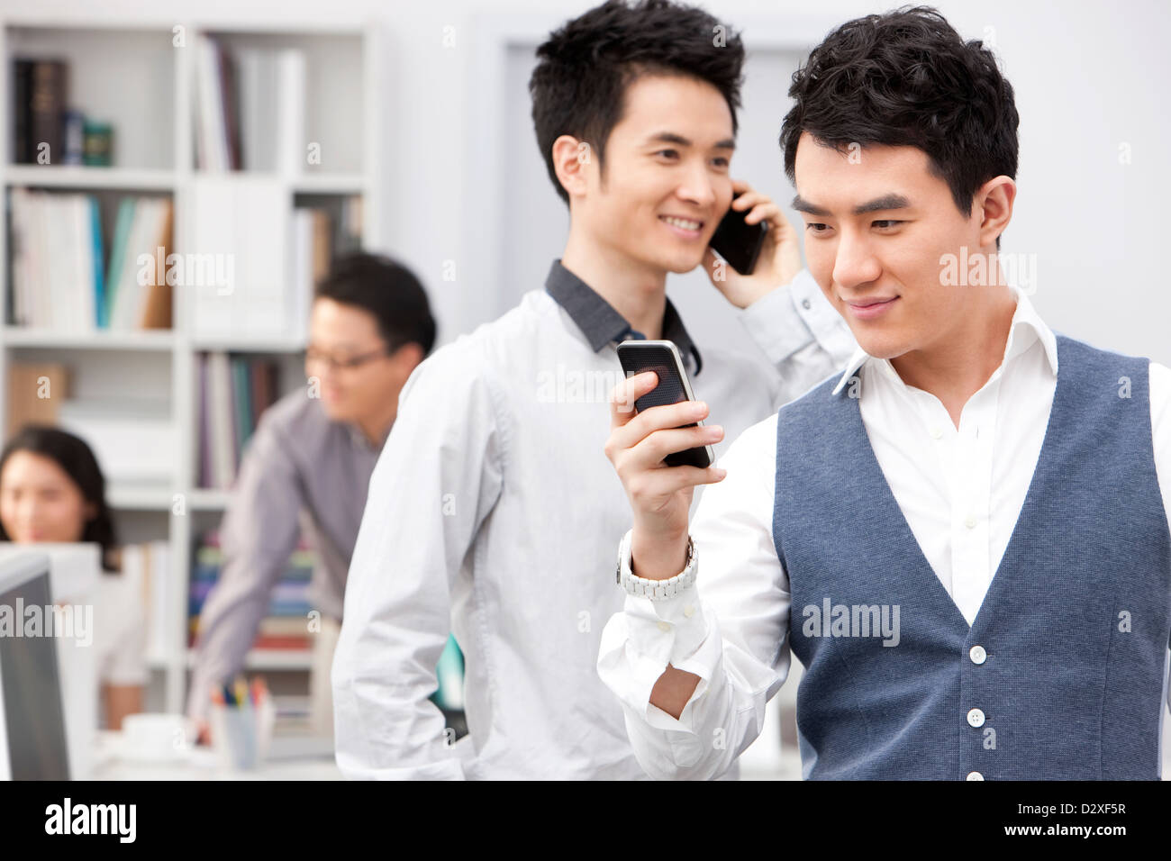 Happy business colleagues with smart phones in the office Stock Photo ...