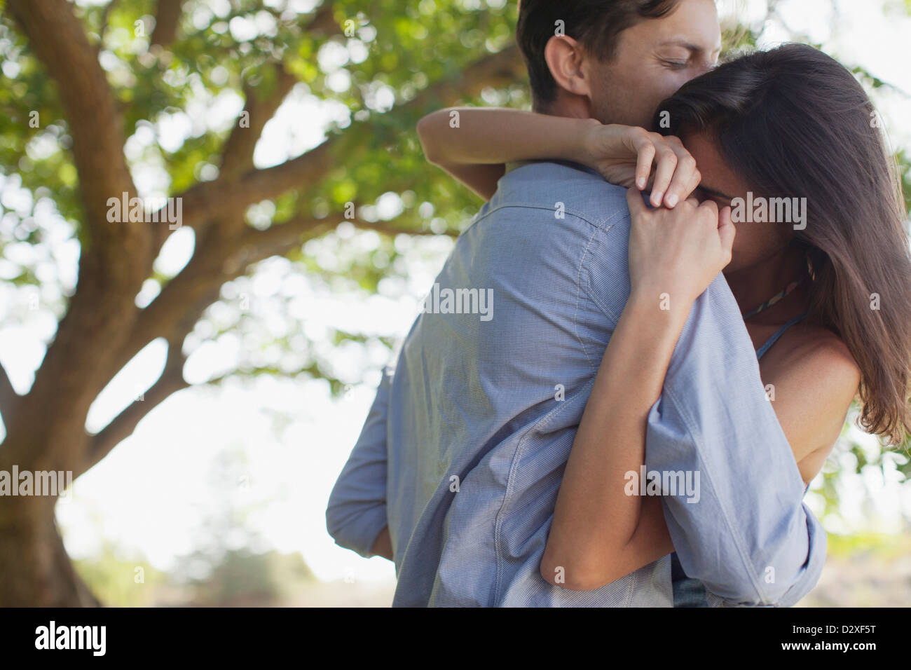 Couple hugging under tree Stock Photo - Alamy