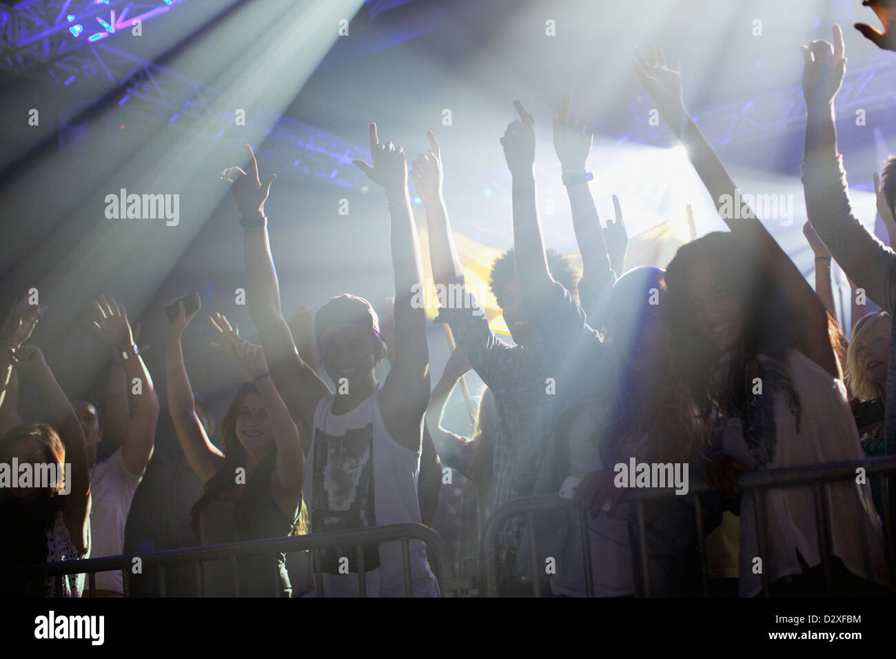 Crowd with arms raised behind railing at concert Stock Photo - Alamy