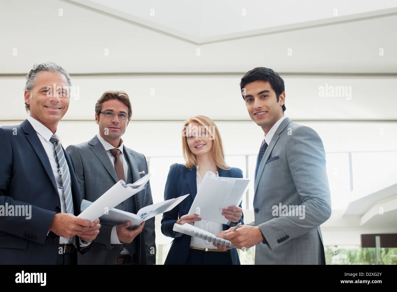 Portrait of smiling business people reviewing paperwork Stock Photo - Alamy