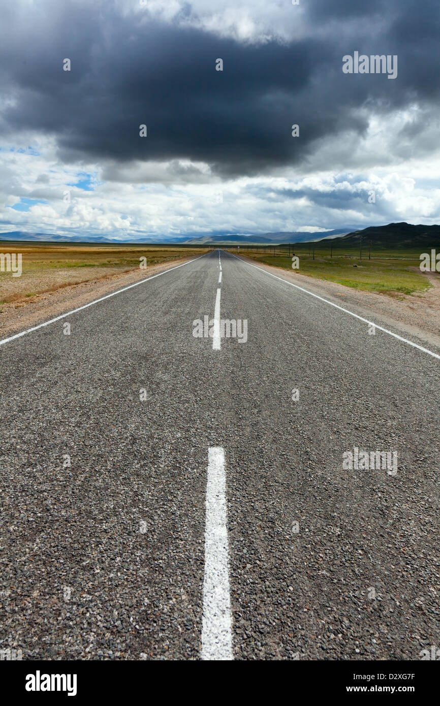 An empty desert road with dark and foreboding storm clouds on the ...