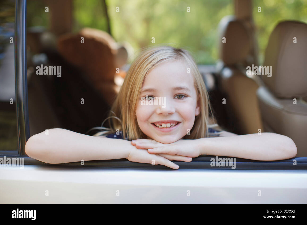 Smiling girl leaning out car window Stock Photo - Alamy