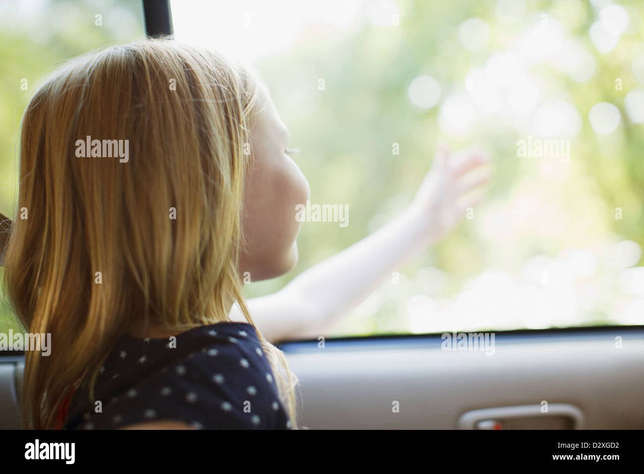 Girl reaching out of car window Stock Photo - Alamy