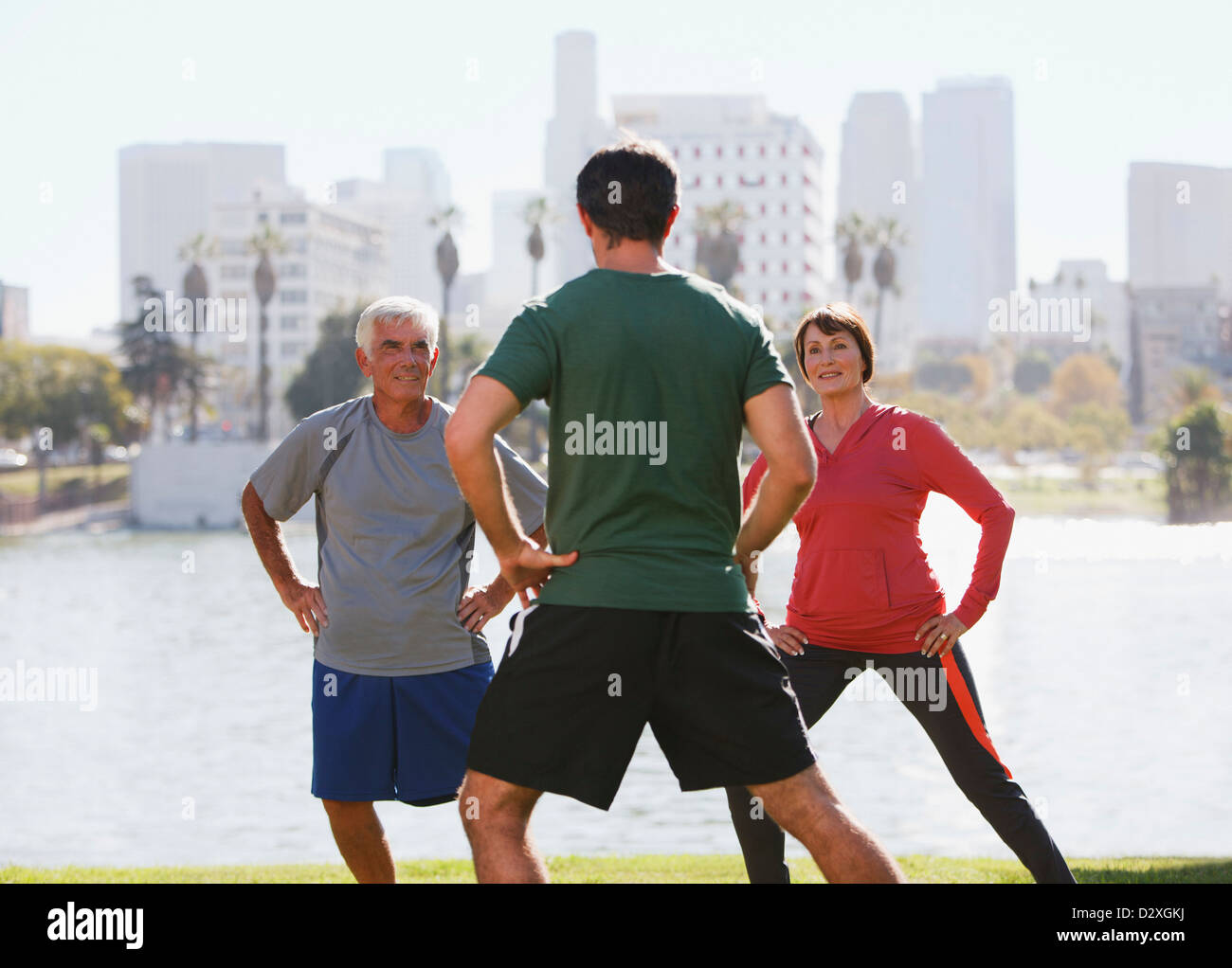 Older couple exercising with trainer in park Stock Photo - Alamy