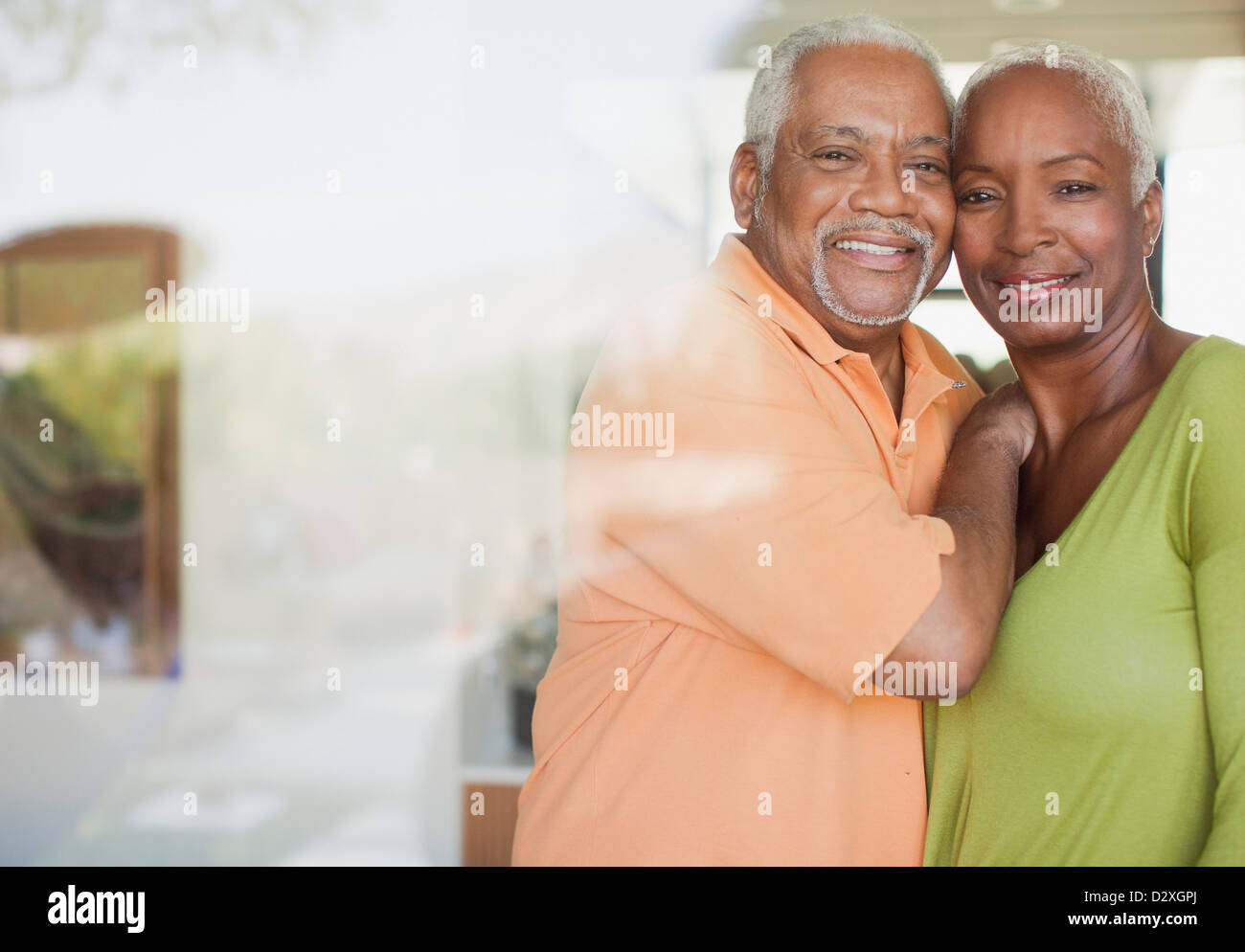 Older couple smiling by window Stock Photo - Alamy