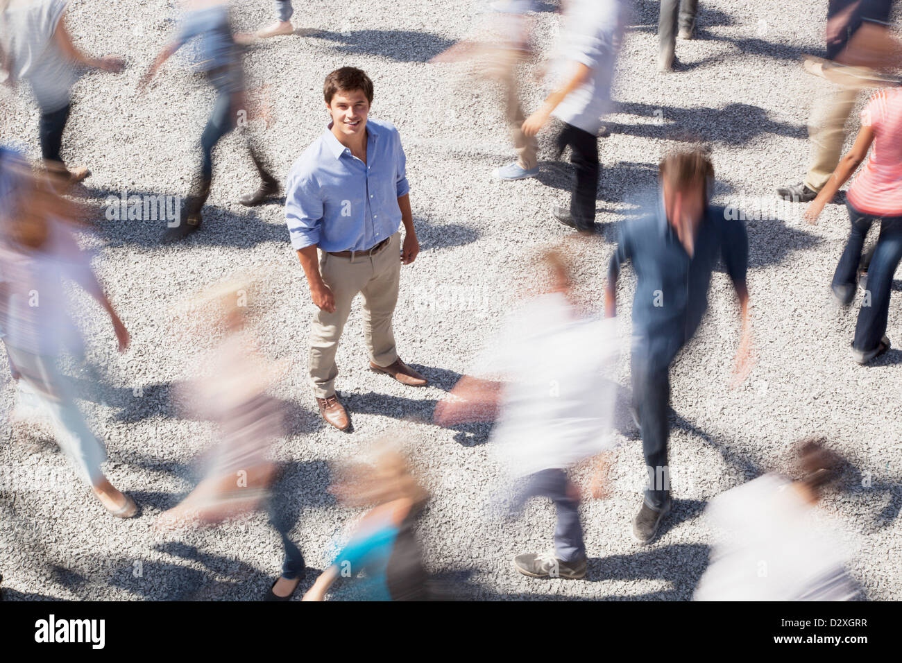 Portrait of smiling businessman surrounded by people rushing by Stock ...
