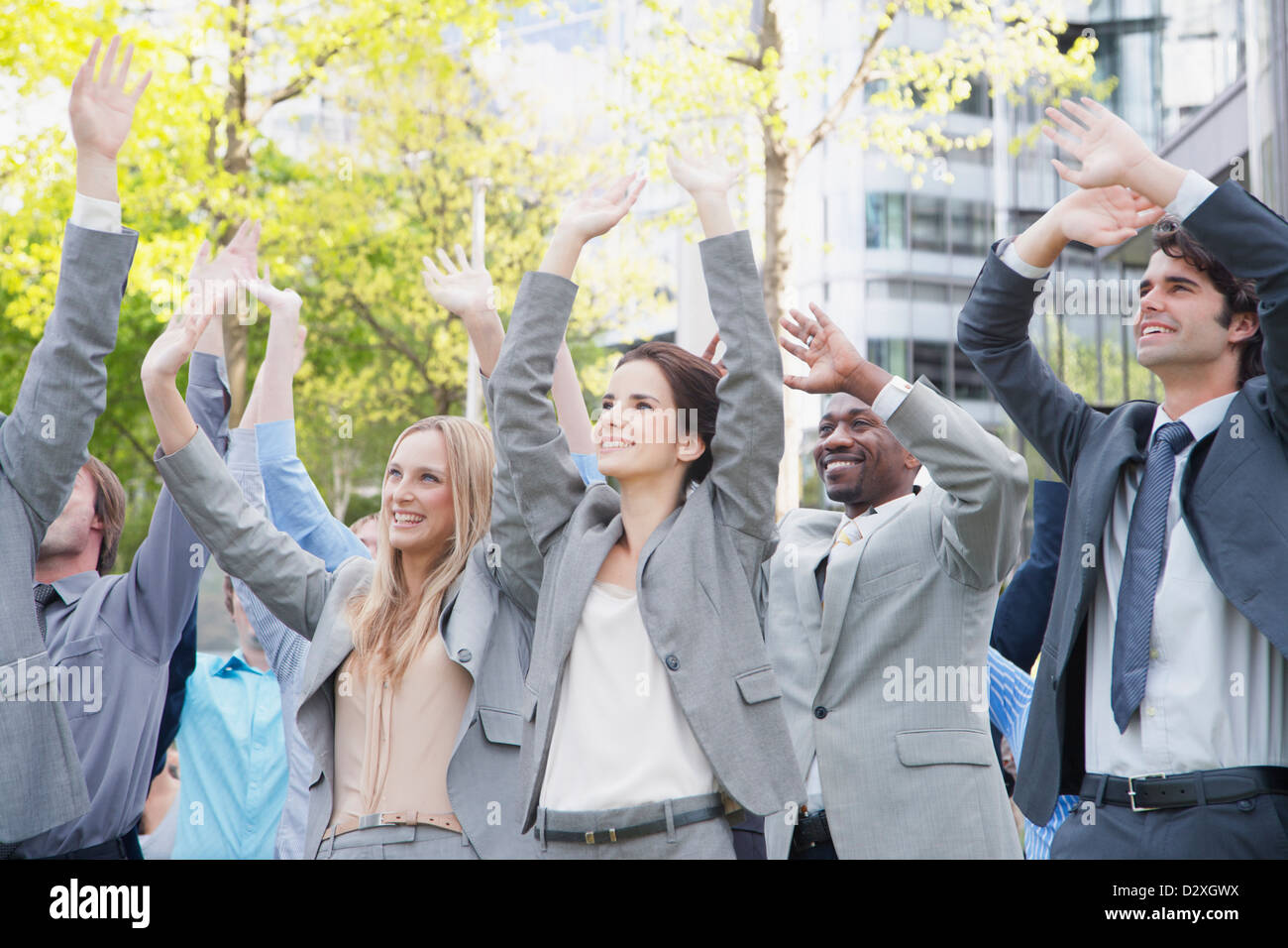 Crowd of business people cheering with arms raised Stock Photo - Alamy