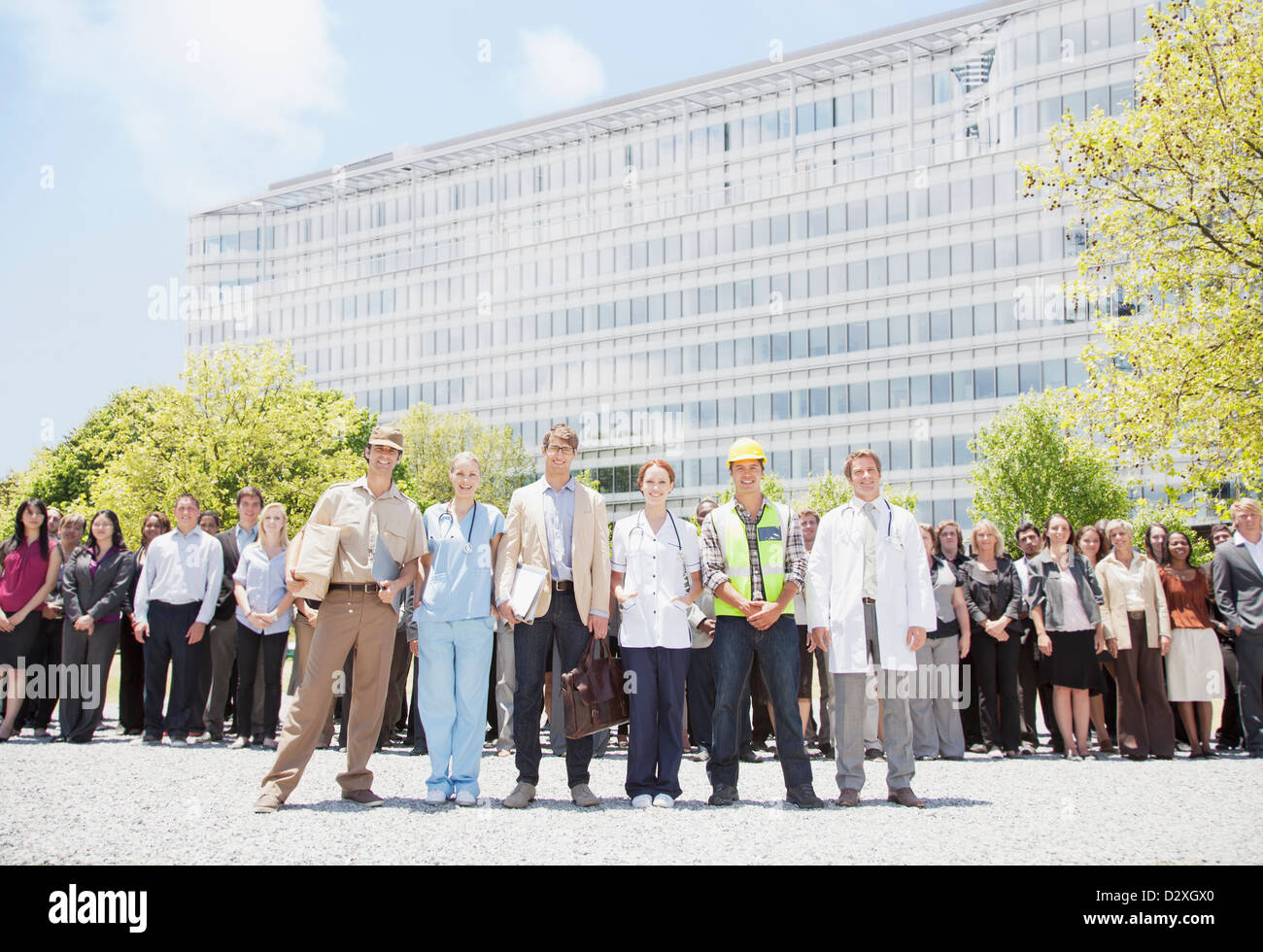 Portrait of professionals and workers with crowd of business people in ...