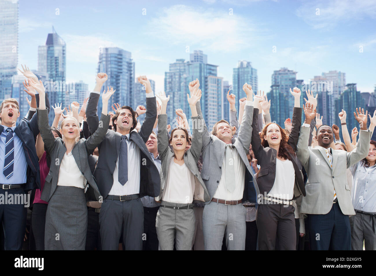 Business people cheering with arms raised in front of skyline Stock ...