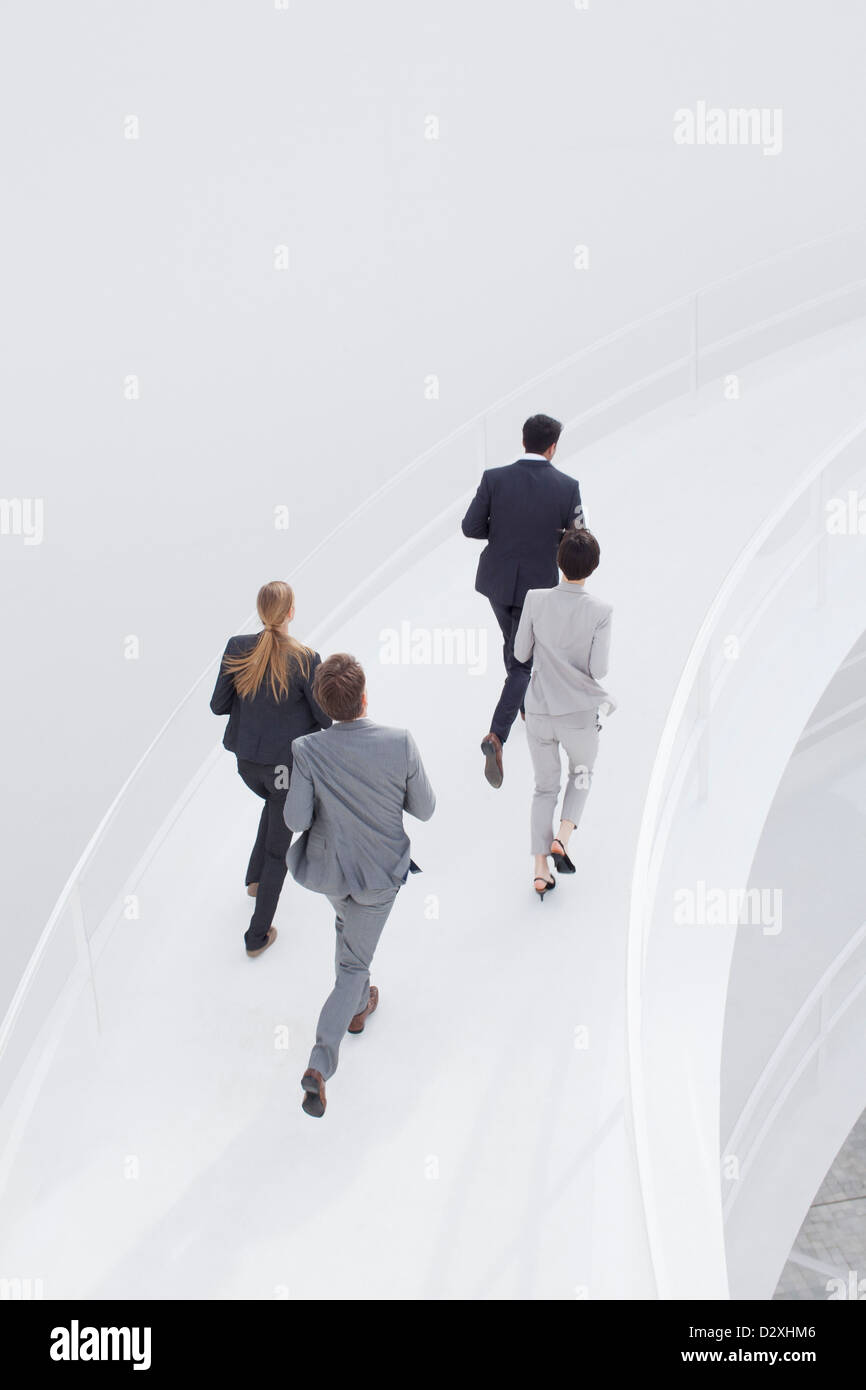 Business people running along elevated walkway Stock Photo - Alamy