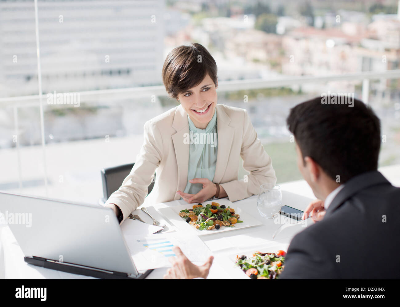 Businessman and businesswoman with laptop meeting over lunch Stock ...