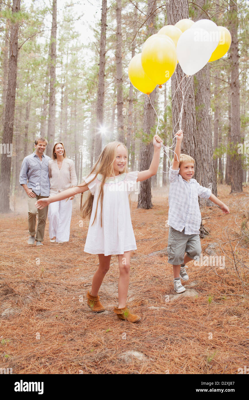 Happy family with balloons in woods Stock Photo - Alamy
