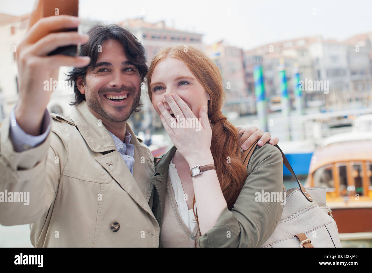Laughing couple taking self-portrait with camera phone in Venice Stock ...