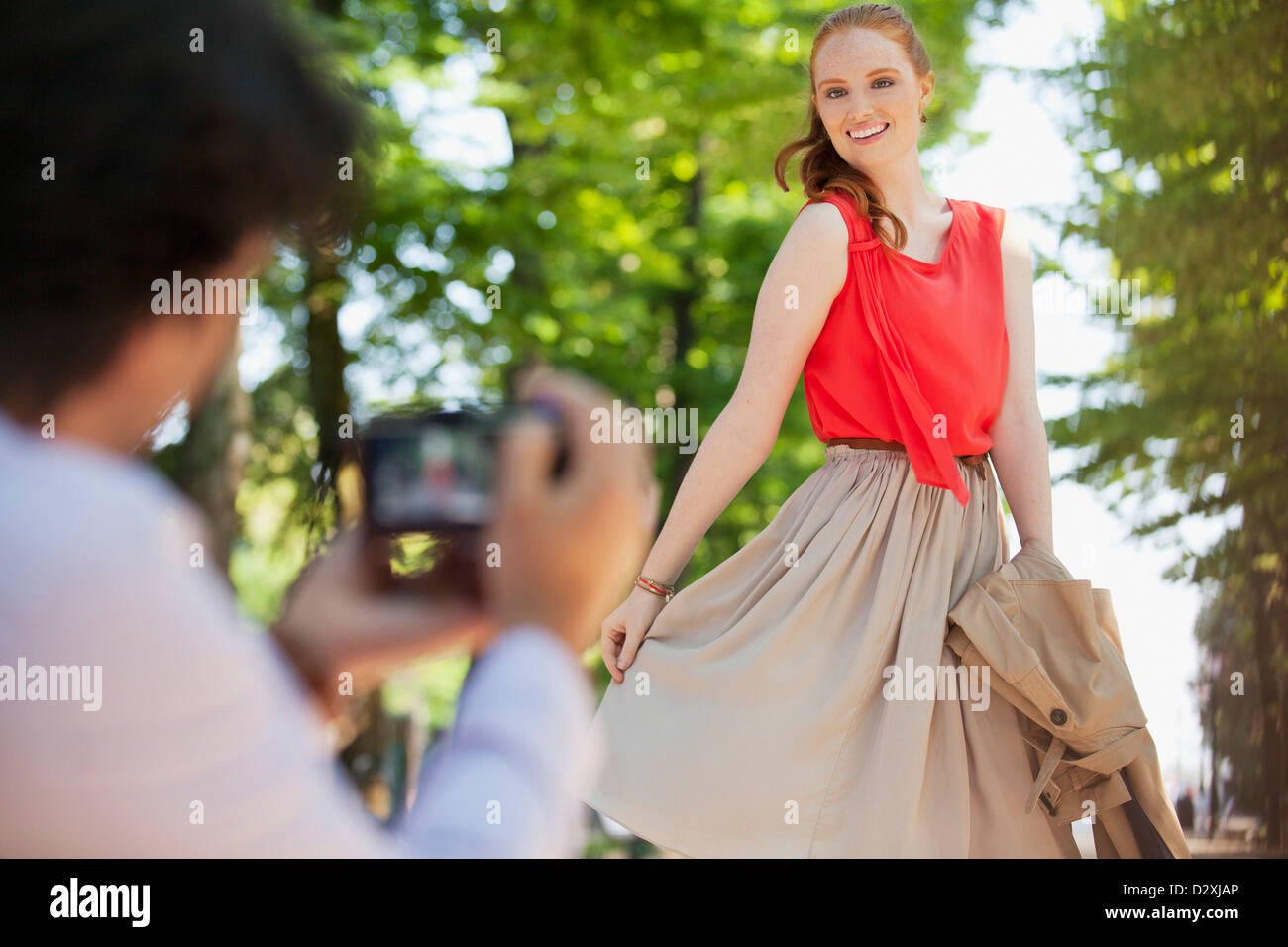 Man photographing woman in park Stock Photo - Alamy