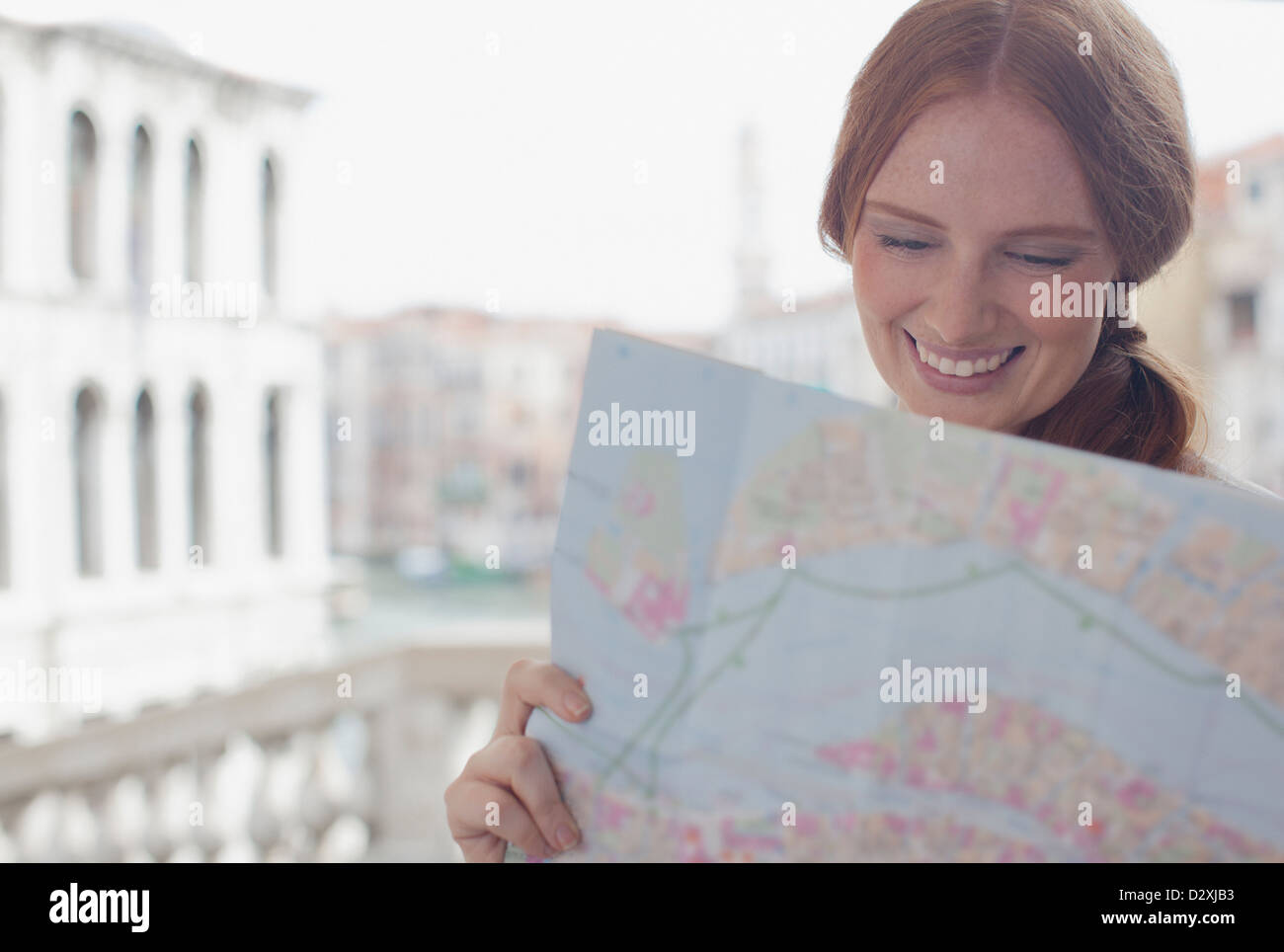 Smiling woman looking down at map Stock Photo - Alamy