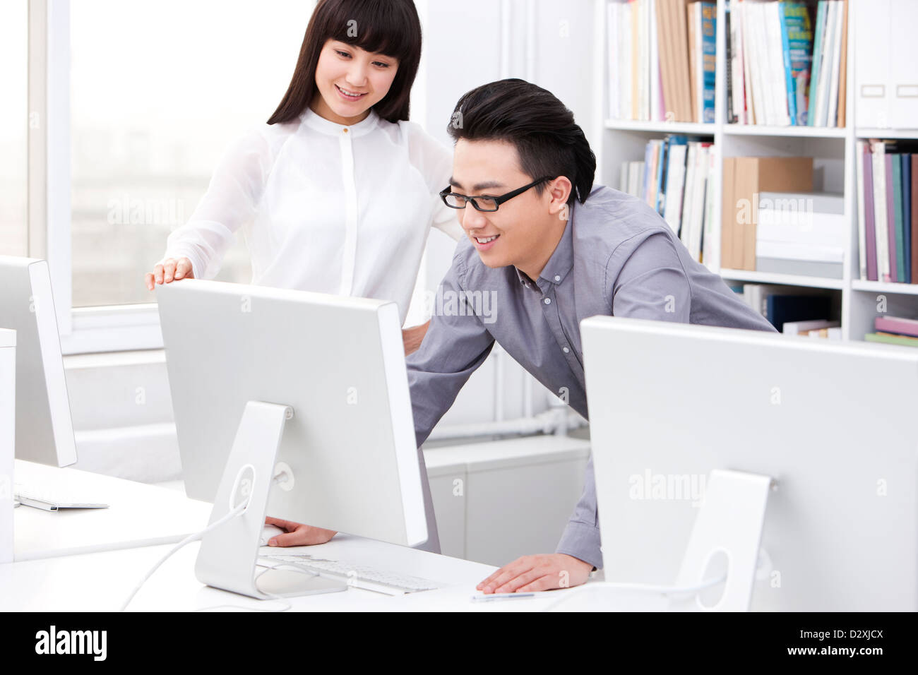 Cheerful office workers using computers in studio Stock Photo - Alamy