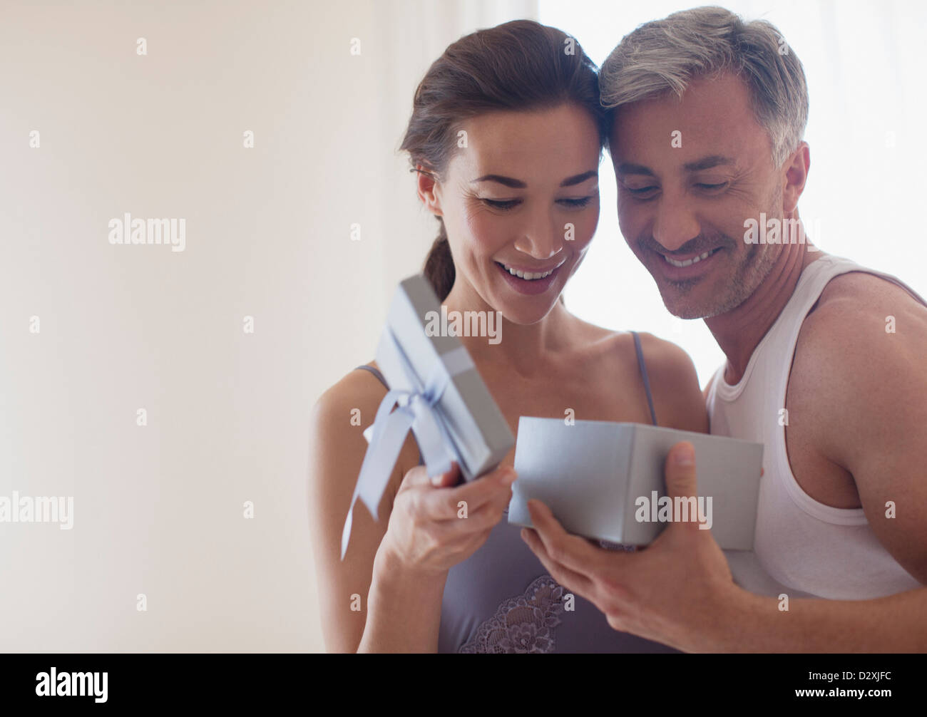 Smiling couple opening gift box Stock Photo - Alamy