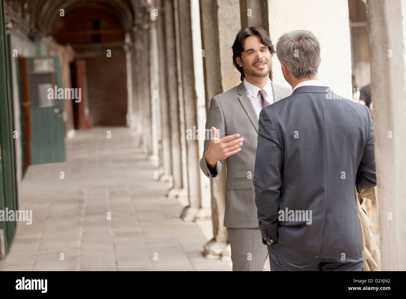 Businessmen talking in corridor Stock Photo - Alamy