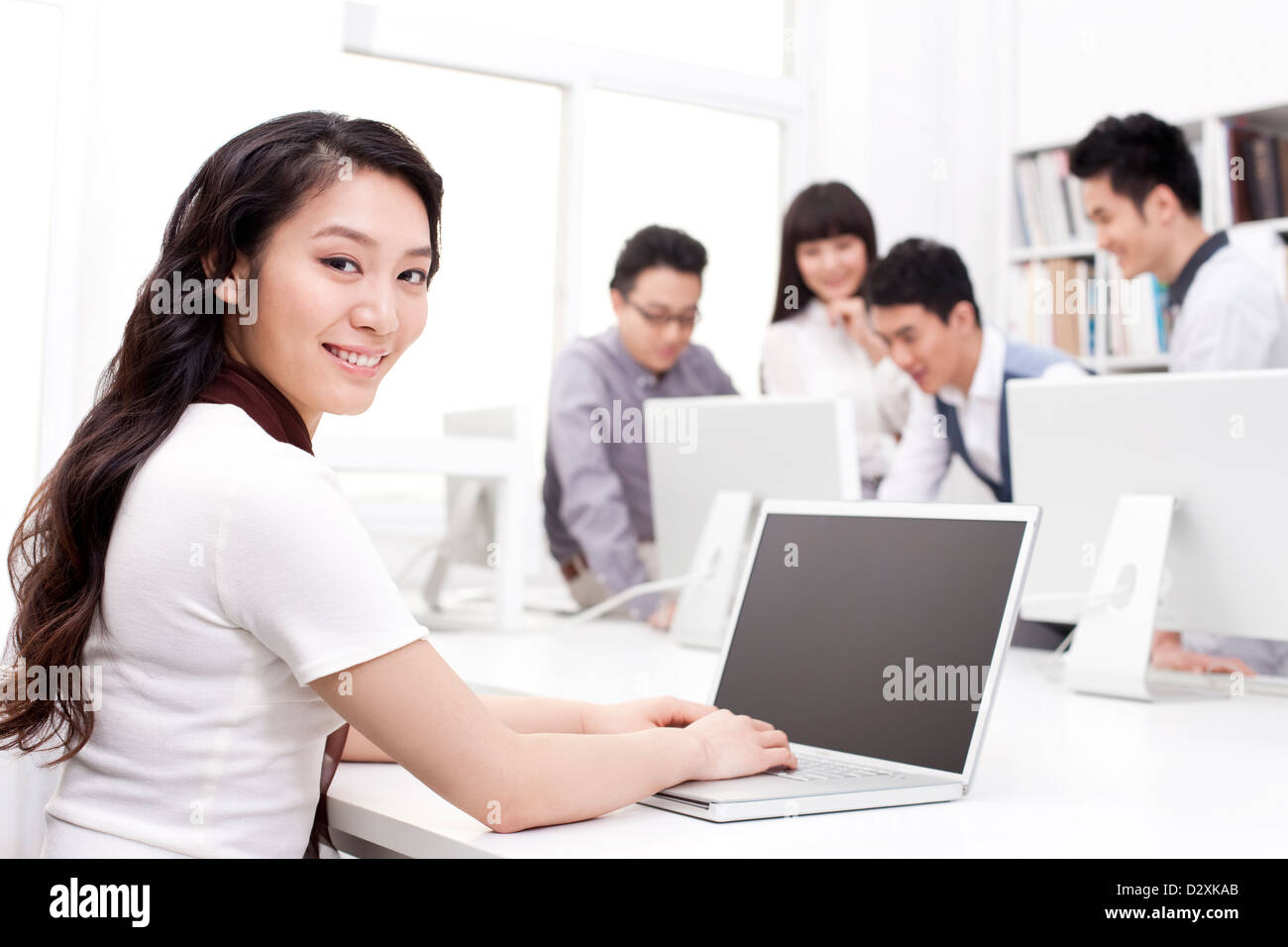 Female office worker using laptop in studio Stock Photo - Alamy