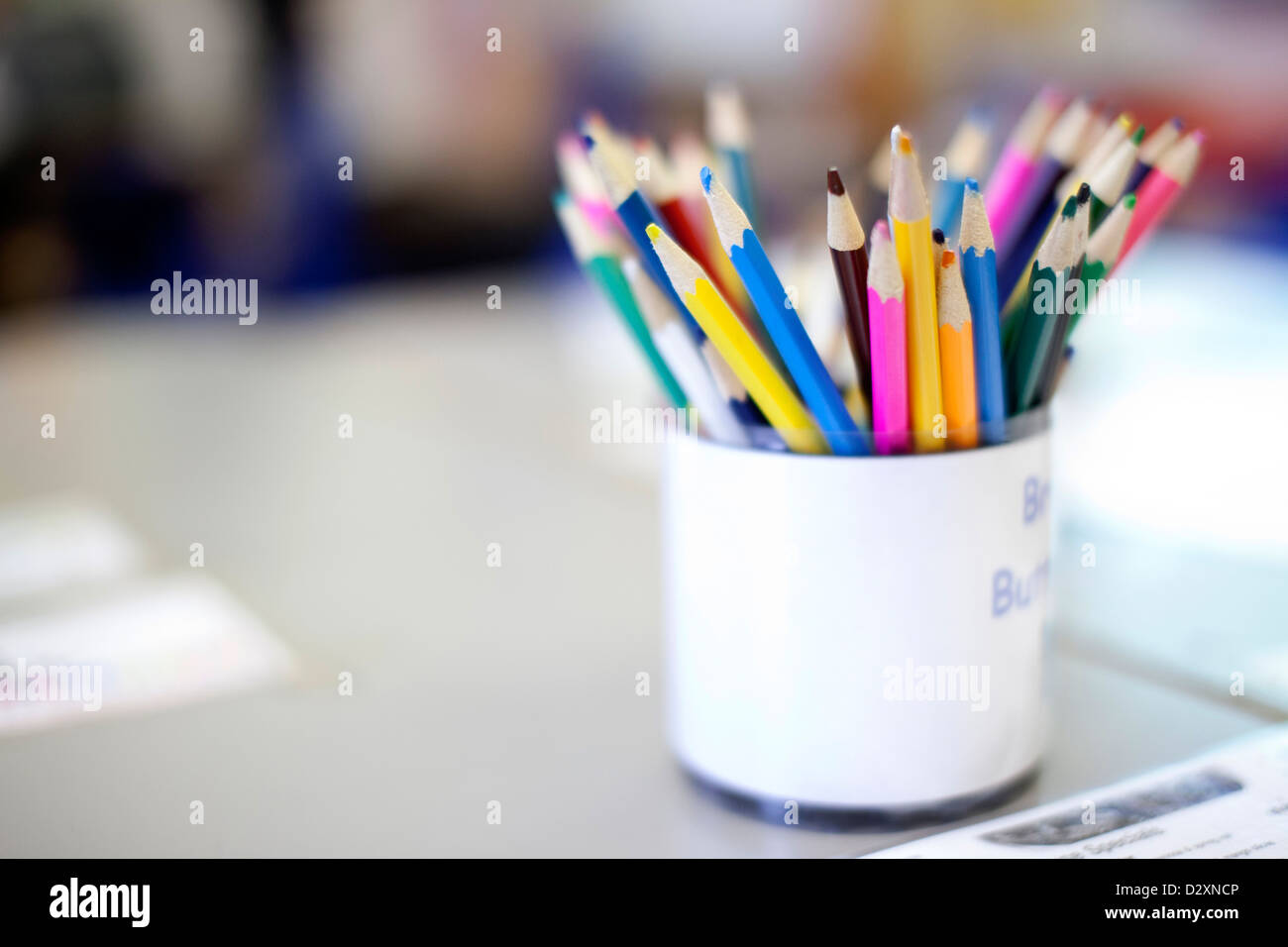 pot of coloured pencils on desk in primary school classroom Stock Photo ...