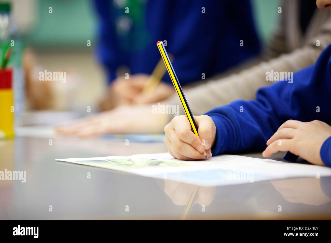 primary school boy writing on work sheet in classroom Stock Photo - Alamy
