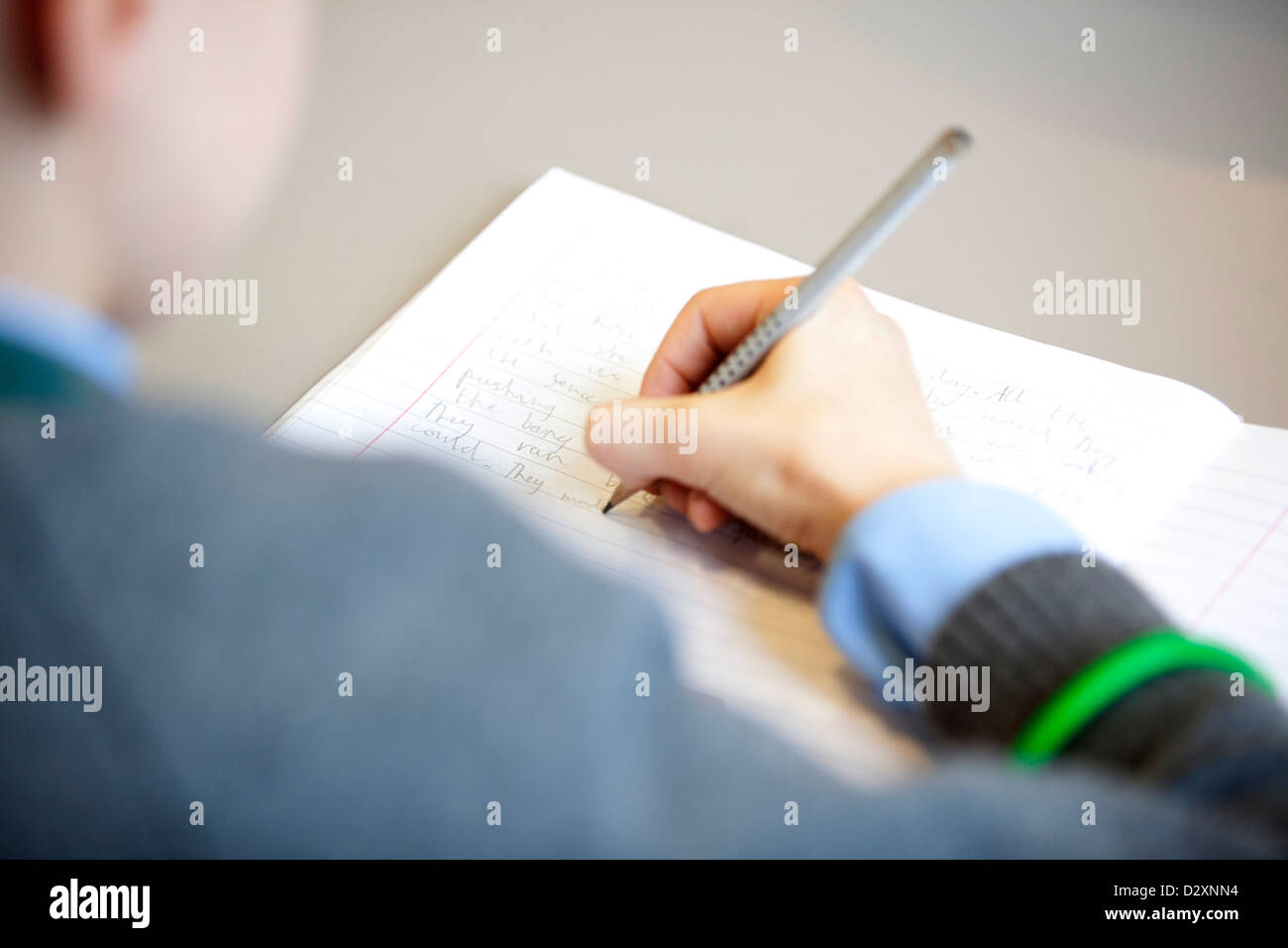 primary school boy writing in exercise book Stock Photo - Alamy