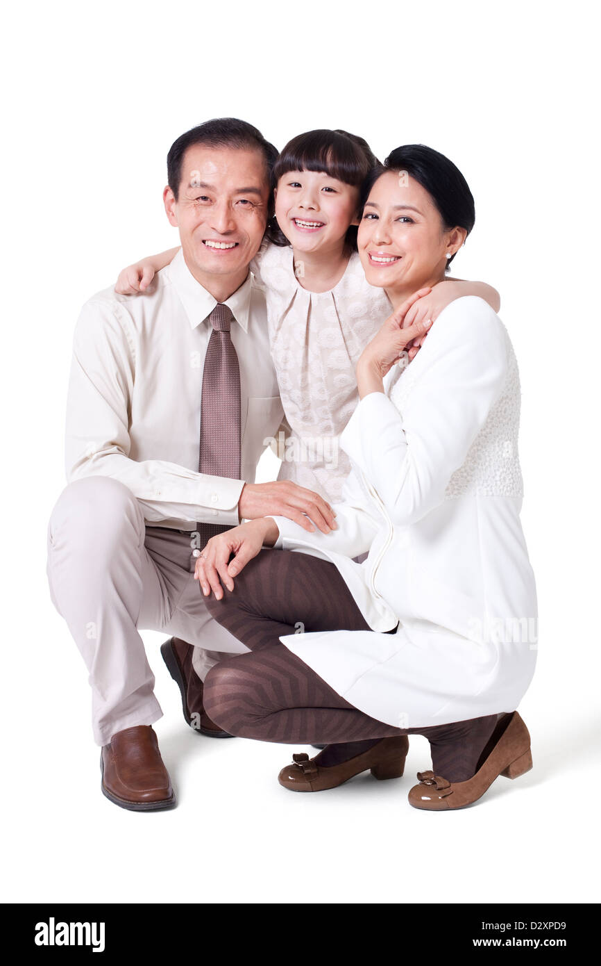 Portrait of cheerful family crouching Stock Photo - Alamy