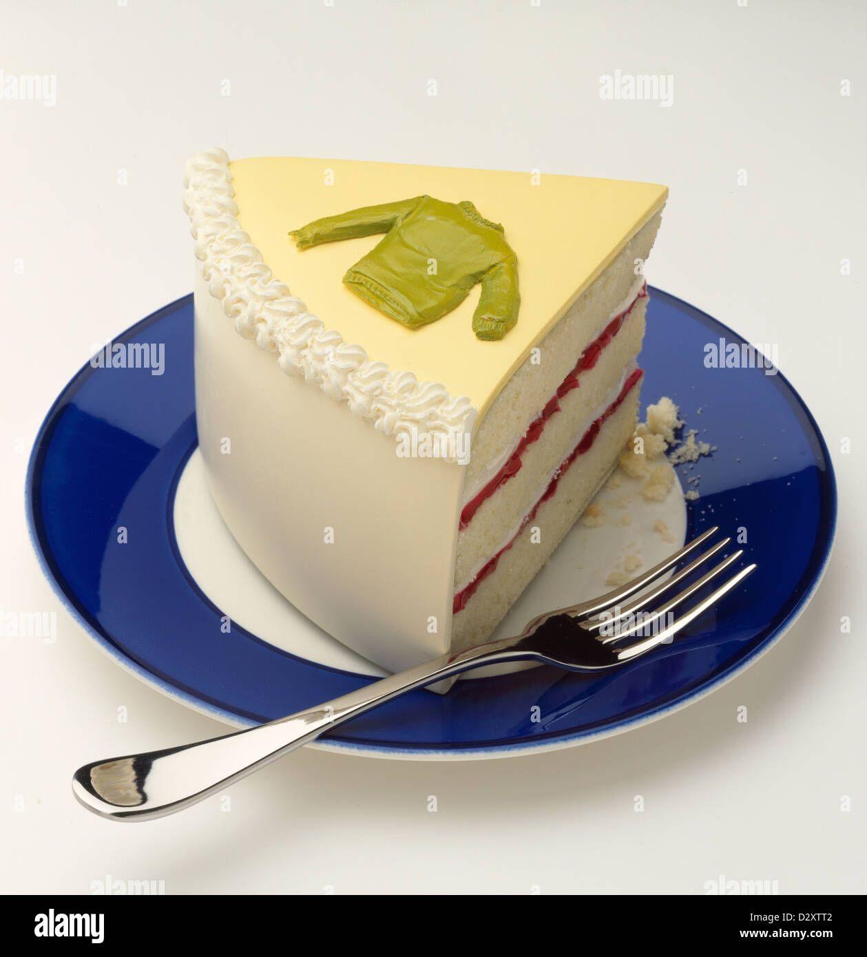 Slice of iced jam sponge cake on plate with fork, football motif Stock ...