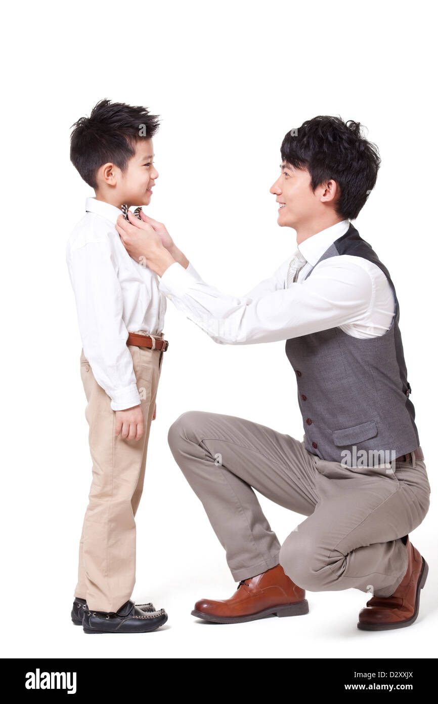 Smiling father fastening bow tie for son Stock Photo - Alamy