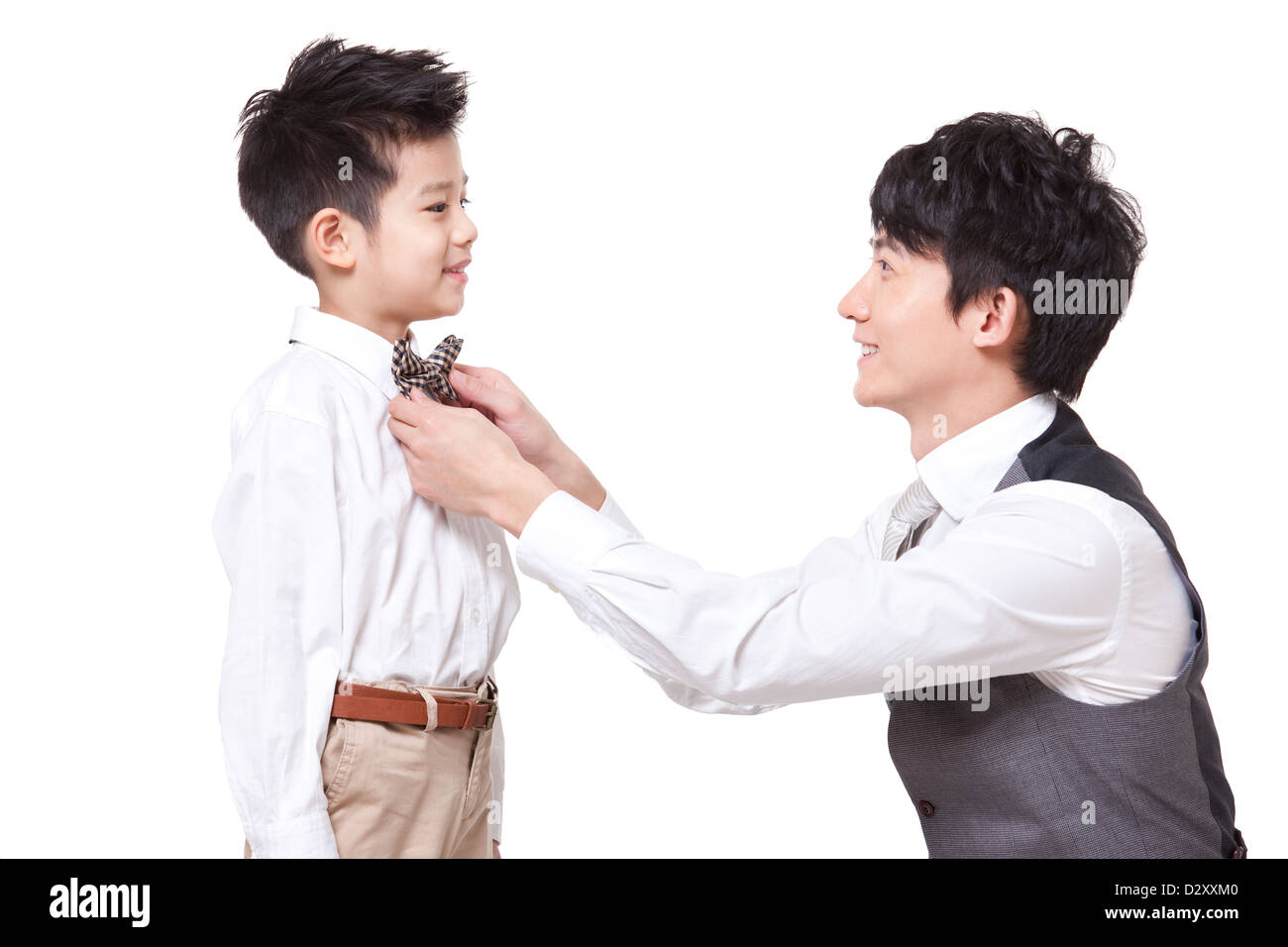 Smiling father fastening bow tie for son Stock Photo - Alamy