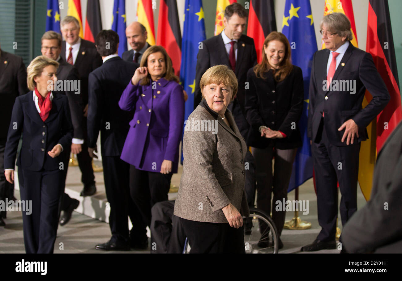 German Chancellor Angela Merkel (C) leaves a photo session of cabinet ...