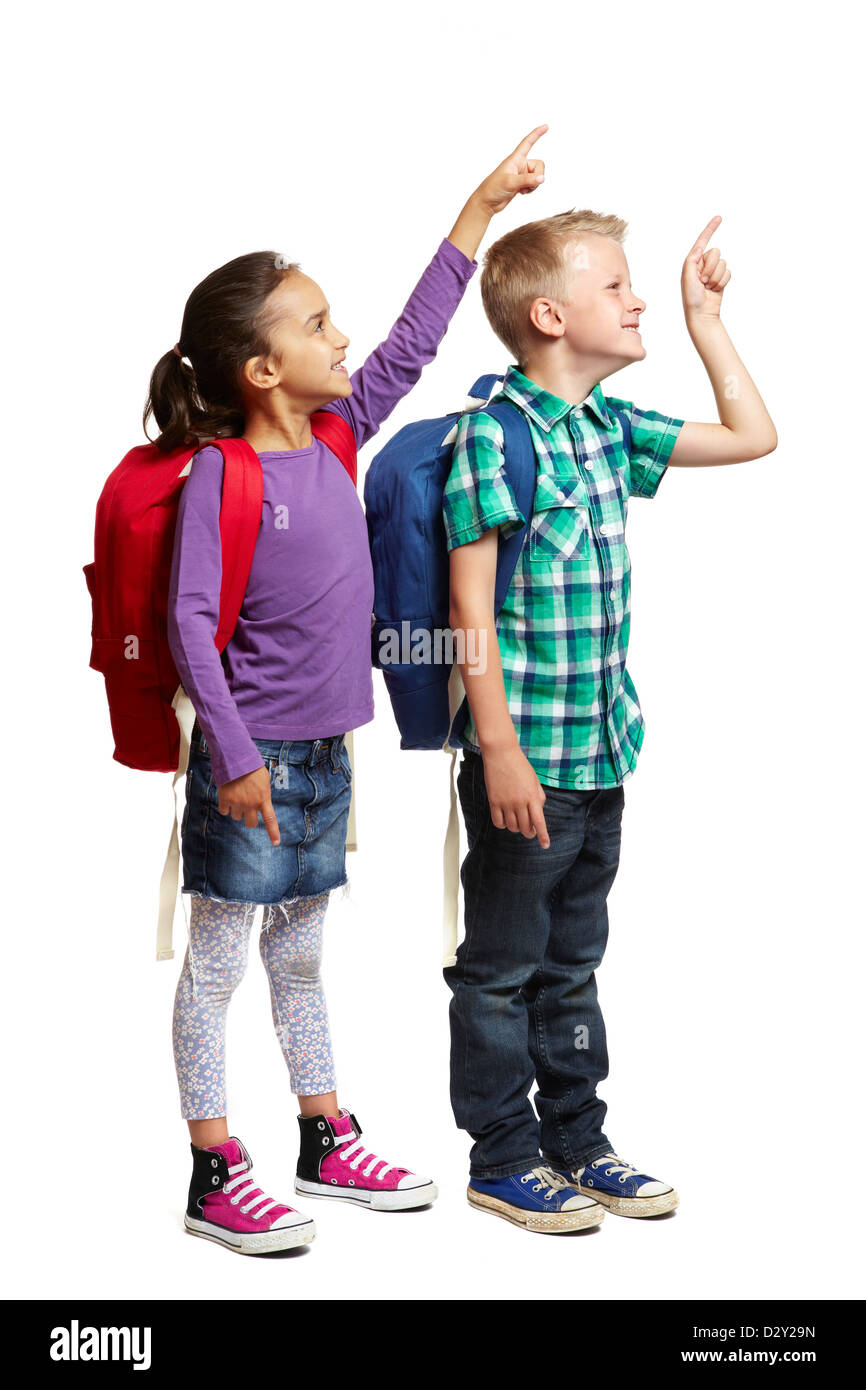 8 year old school boy and girl with backpacks pointing and smiling on ...