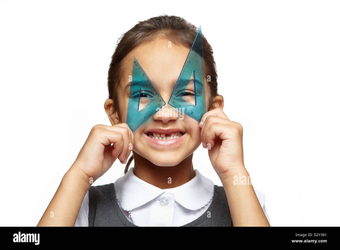 8 year old school girl with blue set squares over her eyes on white ...