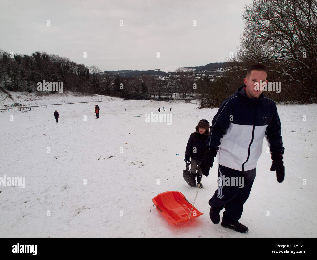 People having fun sledging in the snow of a Brighton park, on a winter ...