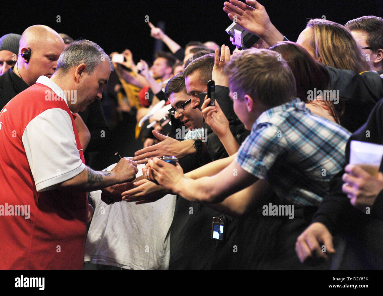 England's 16 time world champion Phil Taylor (L) signs autographs at ...